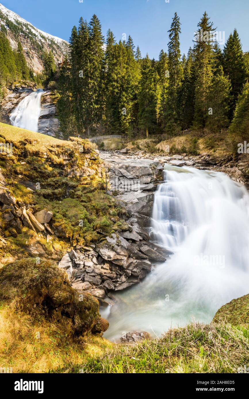 Wide angle view of a double waterfall flowing between trees and rocks ...