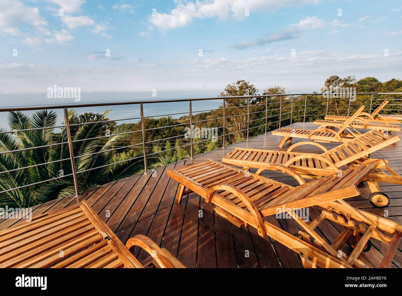 Wooden deck chairs in the hotel with scenic views of the ocean or sea ...