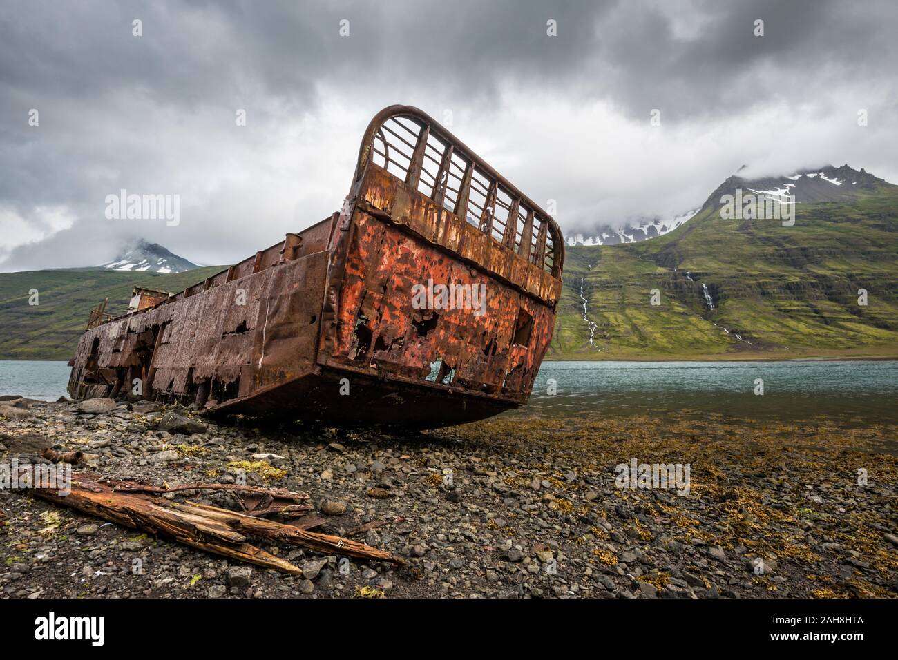Wide angle view of an old, rusty and wrecked cargo ship stranded in a ...