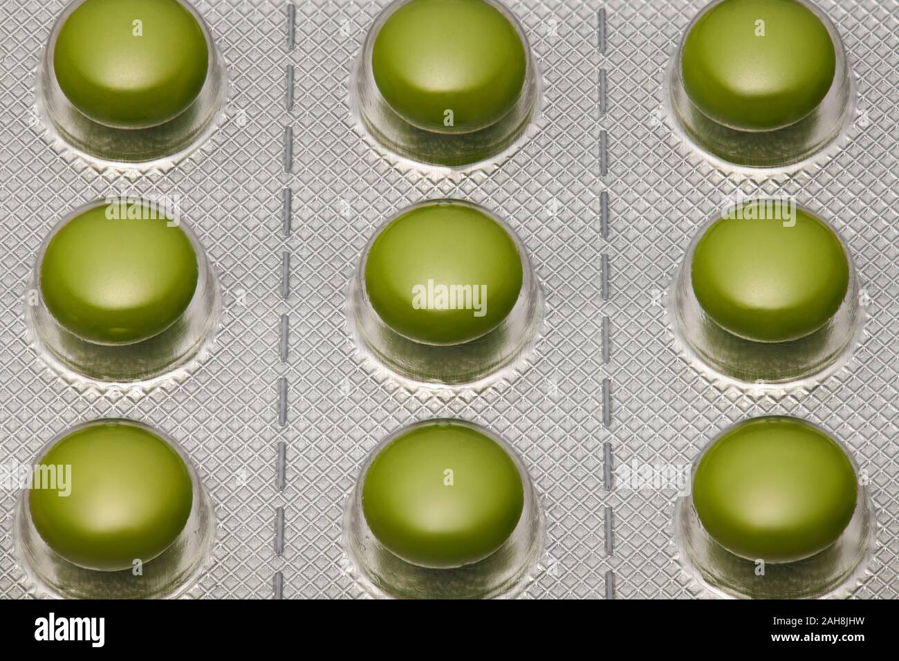 Green tablets in blister pack arranged with beautiful pattern. Global ...