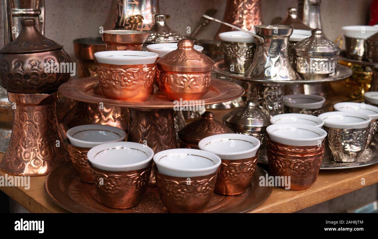 Traditional metal souvenirs at souvenir shop. Copper coffee mugs ...