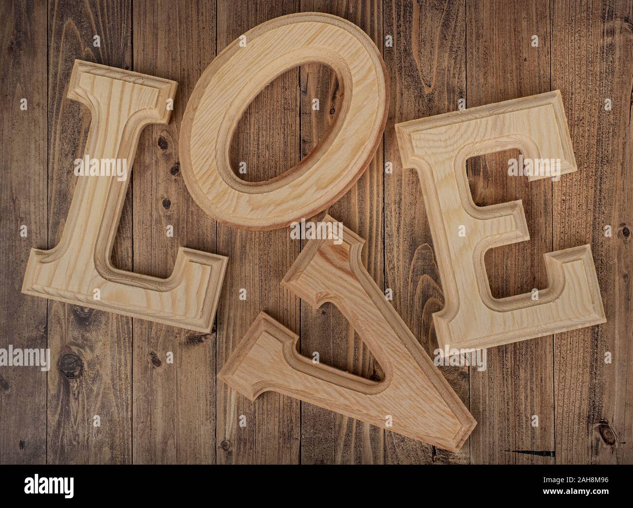 untidy wooden letters forming the word love on a walnut wood background ...