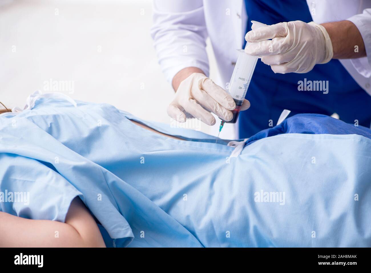 The female patient getting an injection in the clinic Stock Photo - Alamy