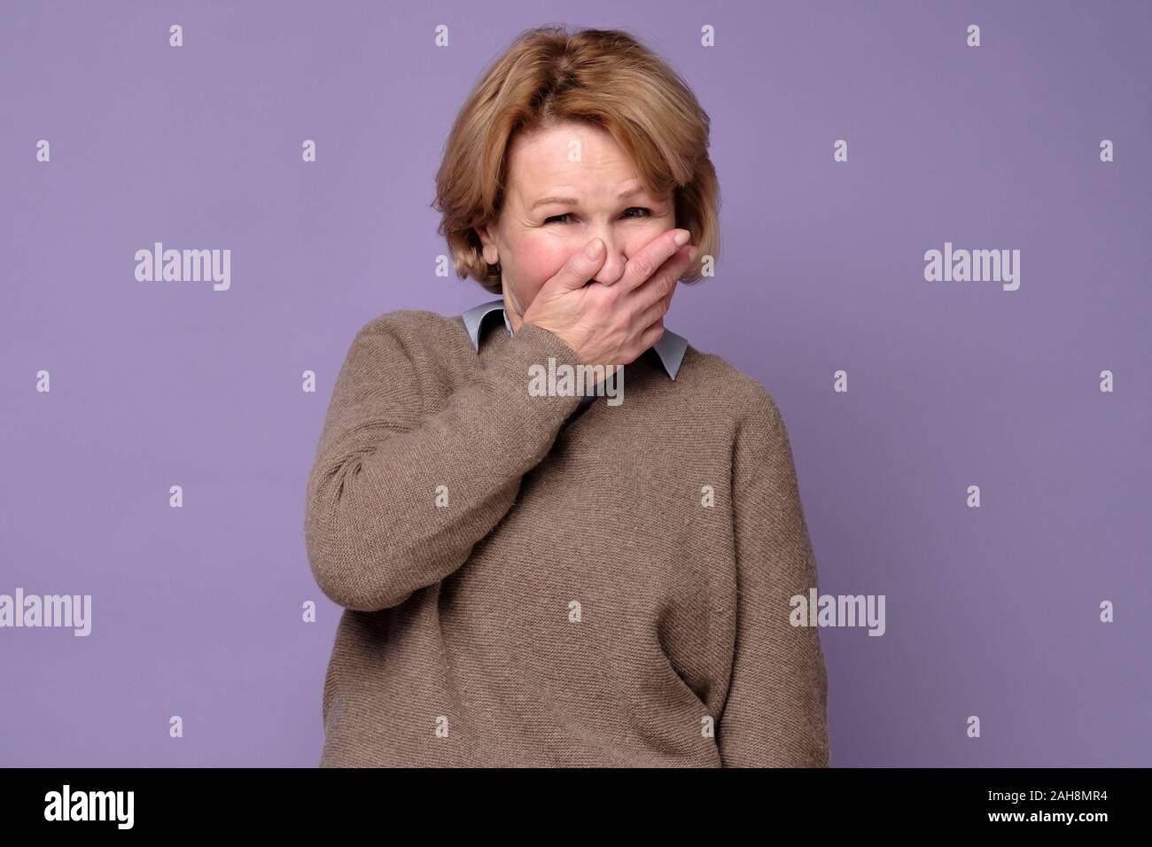 Woman hand over mouth mature hi-res stock photography and images - Alamy