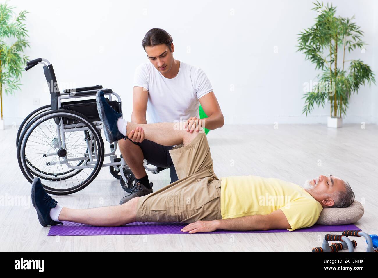 The old injured man doing exercises indoors Stock Photo - Alamy