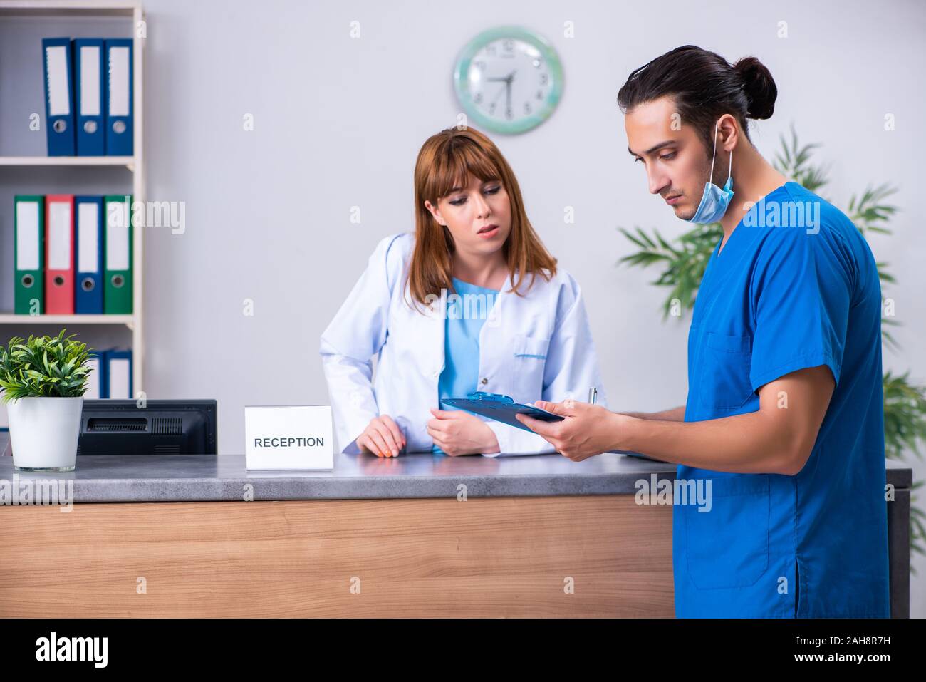 The two doctors working at the reception in the hospital Stock Photo ...