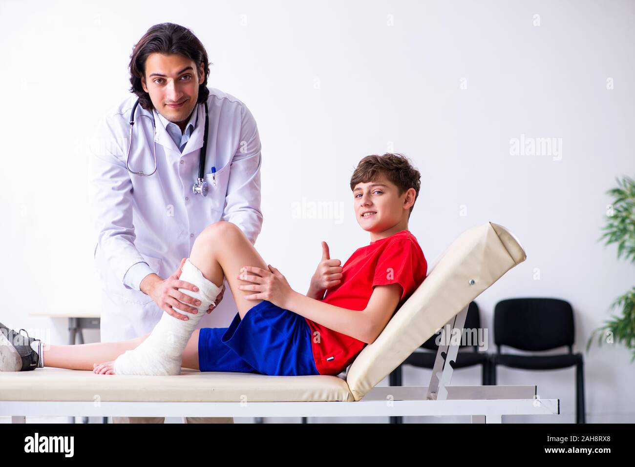 The leg injured boy visiting young doctor traumatologist Stock Photo ...