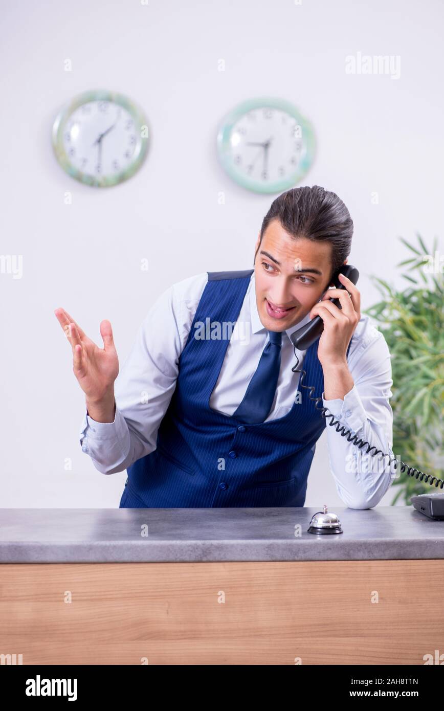 The young man receptionist at the hotel counter Stock Photo - Alamy