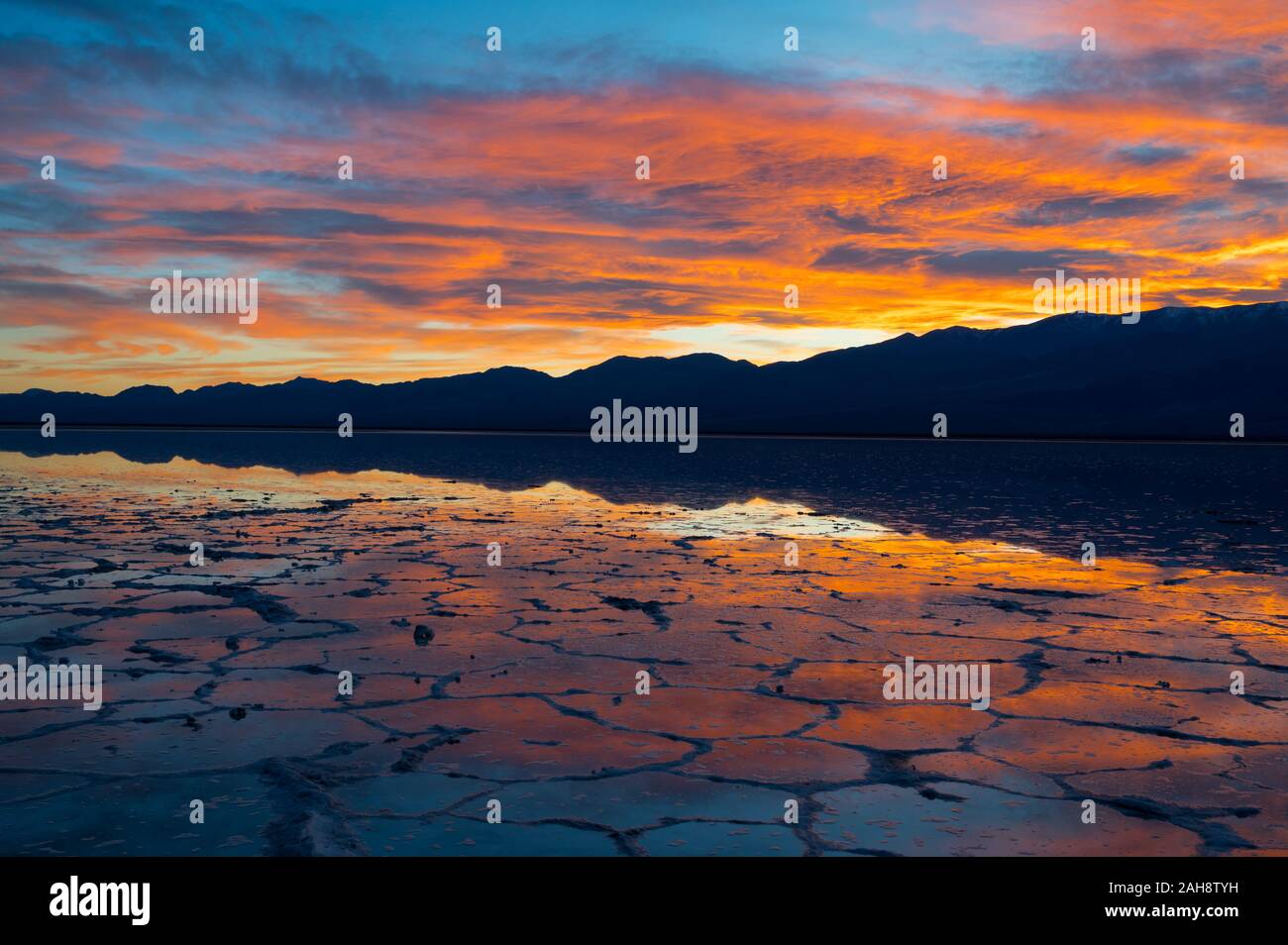 Colourful sunset over a flooded Badwater Basin in the Death Valley ...
