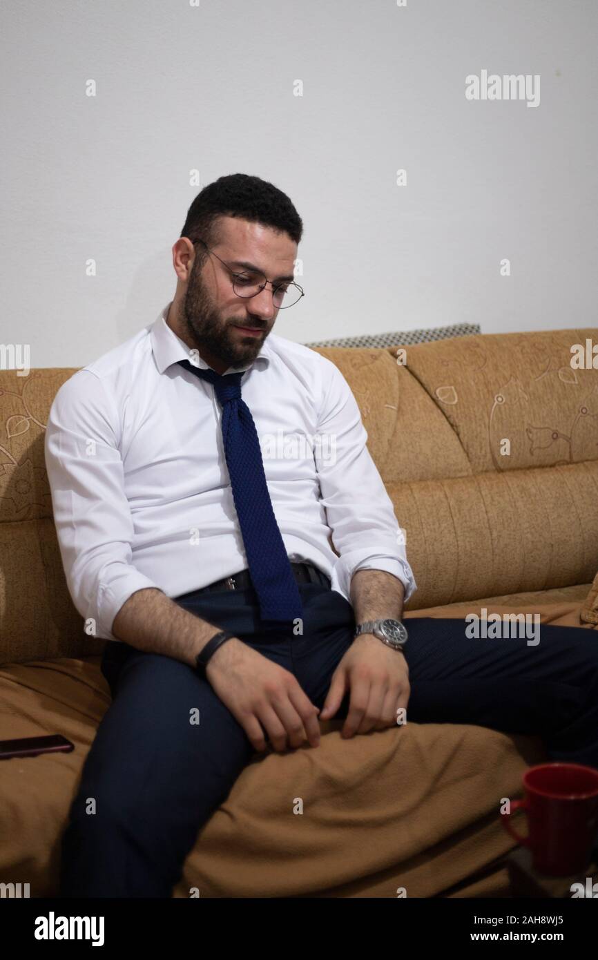 man after work really tired and exhausted in the couch Stock Photo - Alamy