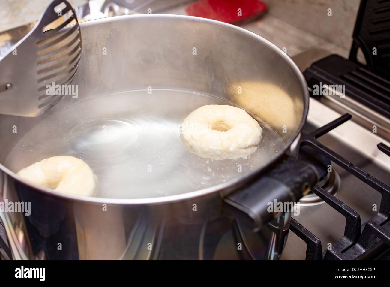 Homemade process of boiling homemade bagels in a pan of water Stock ...