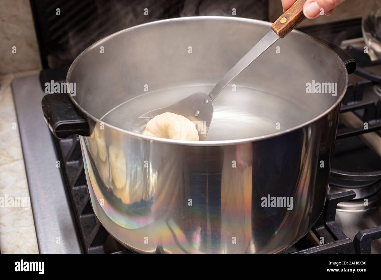 Homemade process of boiling homemade bagels in a pan of water Stock ...