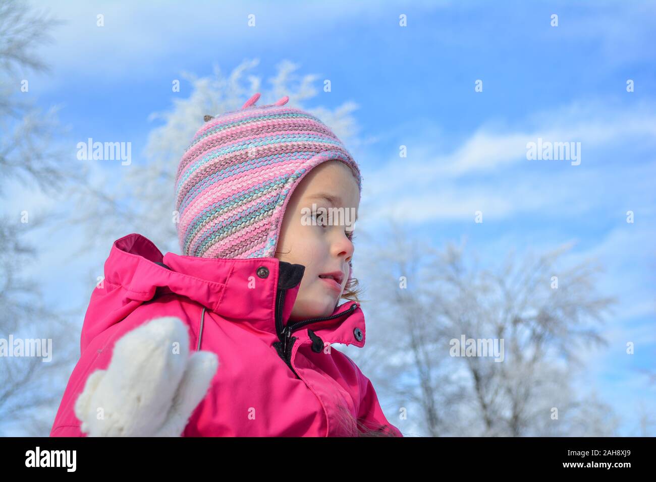 Portrait of young girl in winter clothes and colorful woolen hat ...