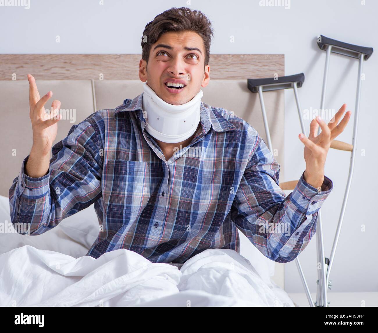 Injured man in bed at home with crutches Stock Photo - Alamy