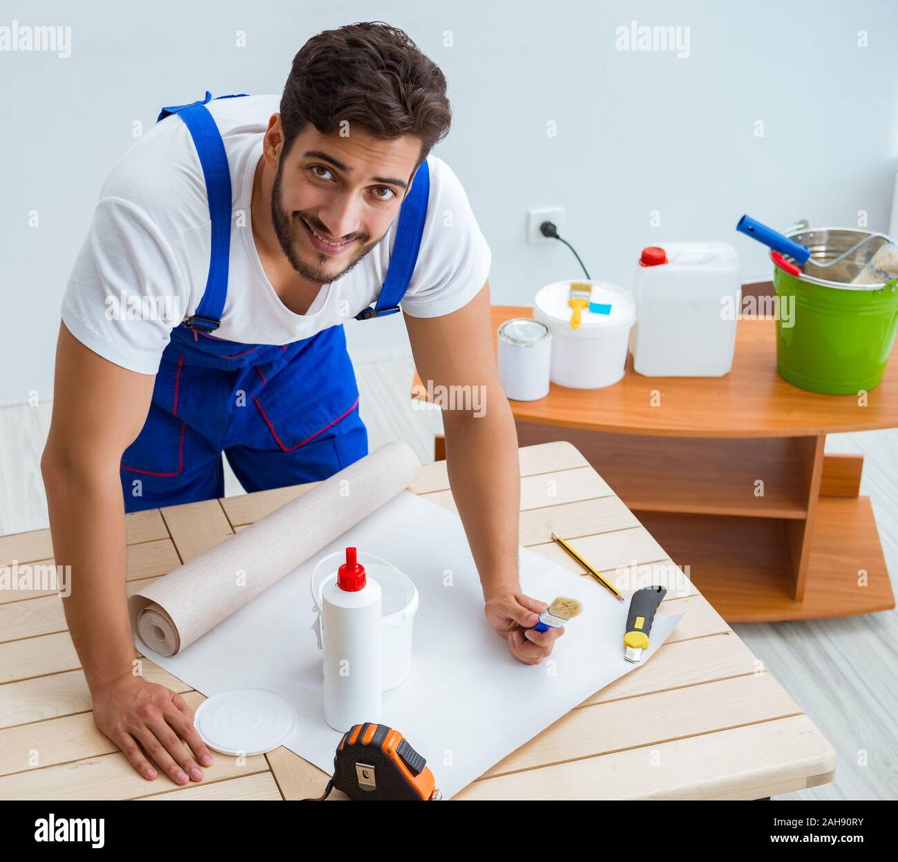 The worker working on wallpaper during refurbishment Stock Photo - Alamy