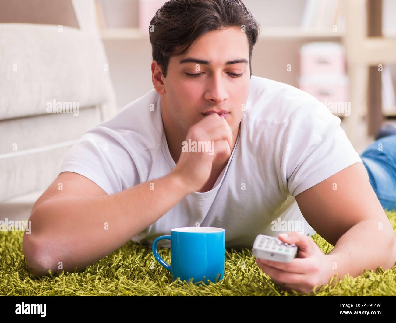The man watching tv at home on floor Stock Photo - Alamy