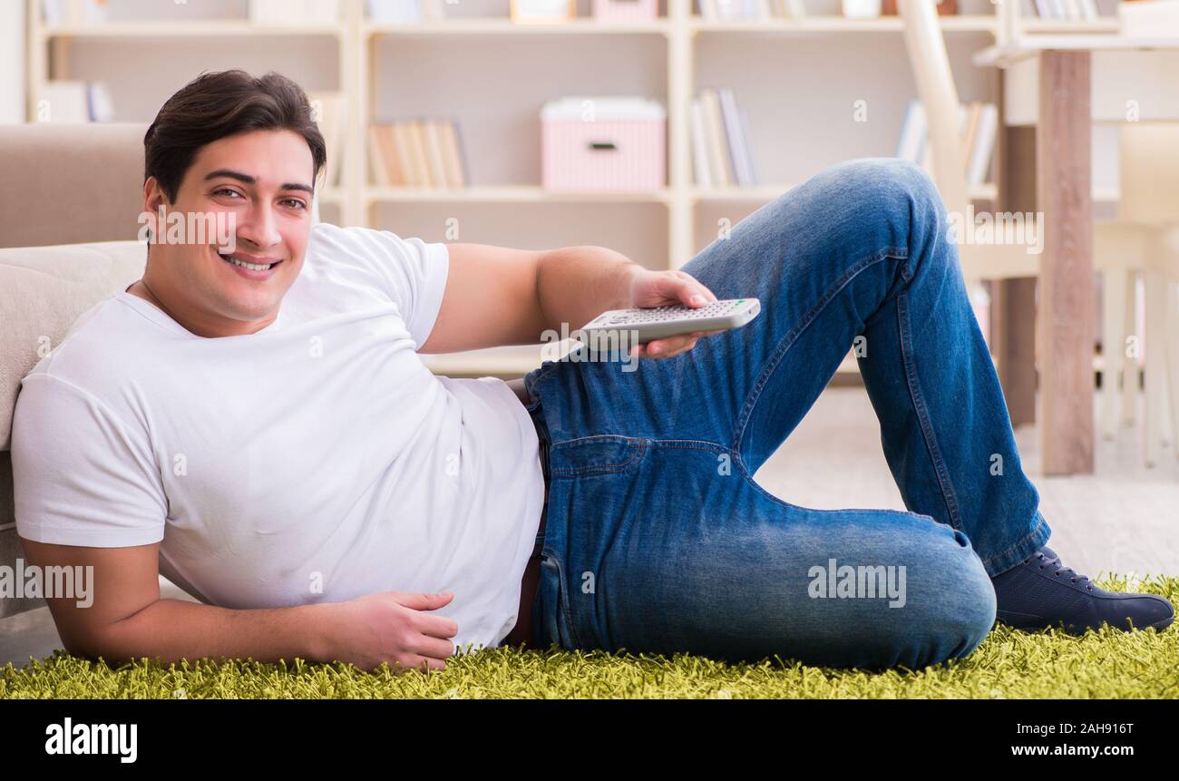 The man watching tv at home on floor Stock Photo - Alamy