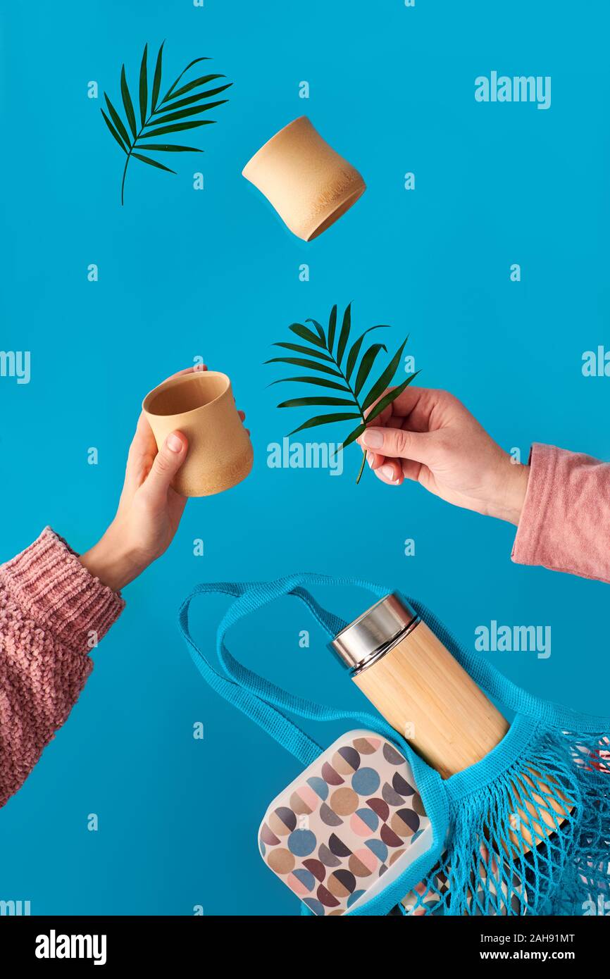 Zero waste tea in in eco friendly insulated bamboo flask. Two hands ...
