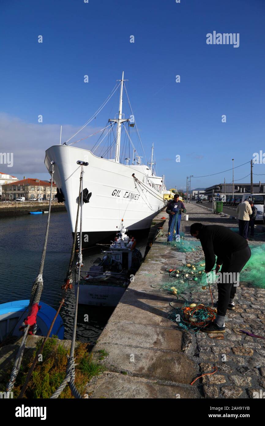 Fishermen checking nets next to former hospital ship Gil Eannes, Marina ...