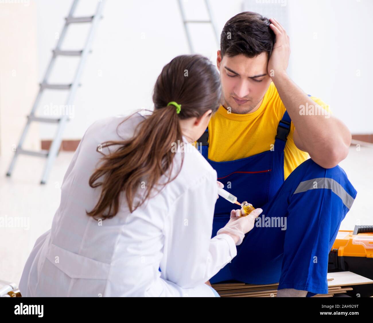 The doctor helping injured worker at construction site Stock Photo - Alamy