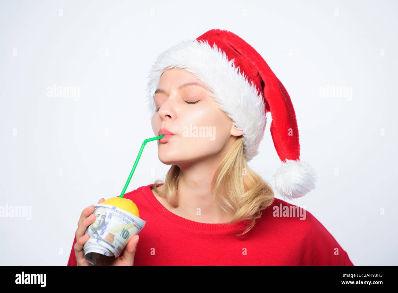 Girl santa hat drink juice lemon wrapped in banknote. Christmas ...