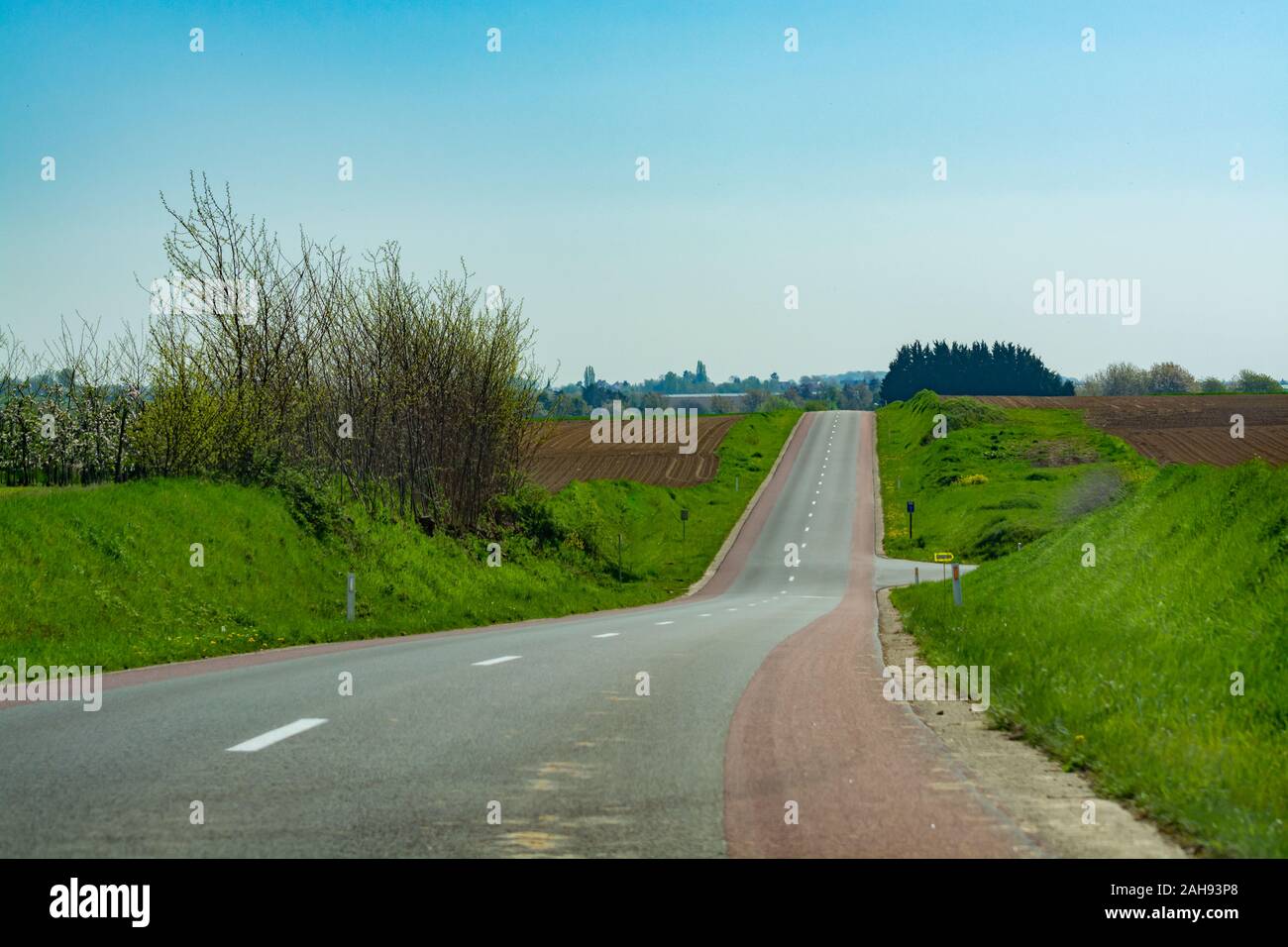 Asphalt road and spring landscape with farmers plowed fields and green ...
