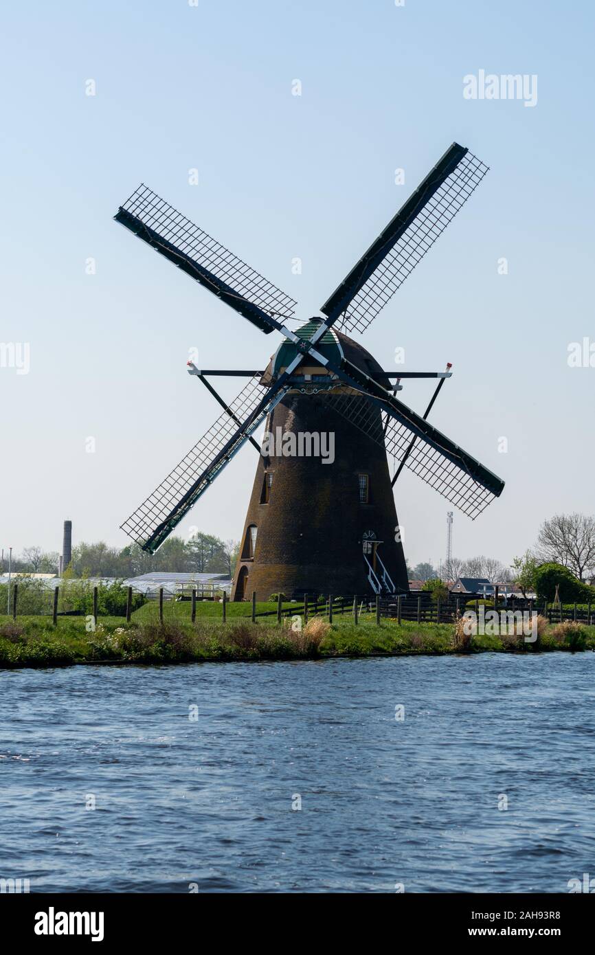 Traditional Dutch wind mill built along canal in North Holland, spring ...