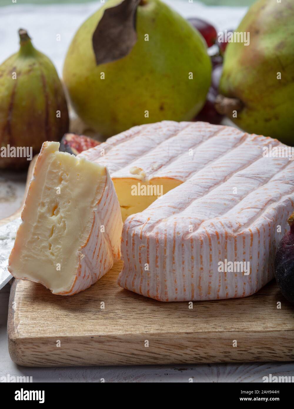 Round piece of French cheese Fleur Rouge made from cow milk served as ...