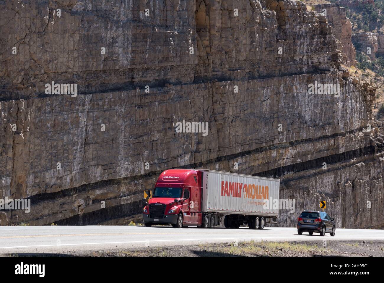 Truck and SUV driving through a road cut with coal seams on Highway 6 ...