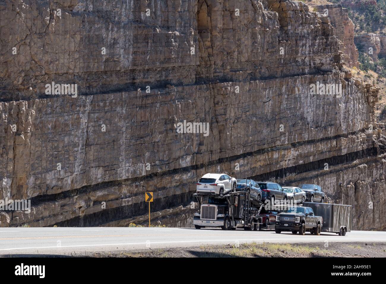 Trucks driving through a road cut with coal seams on Highway 6 in ...