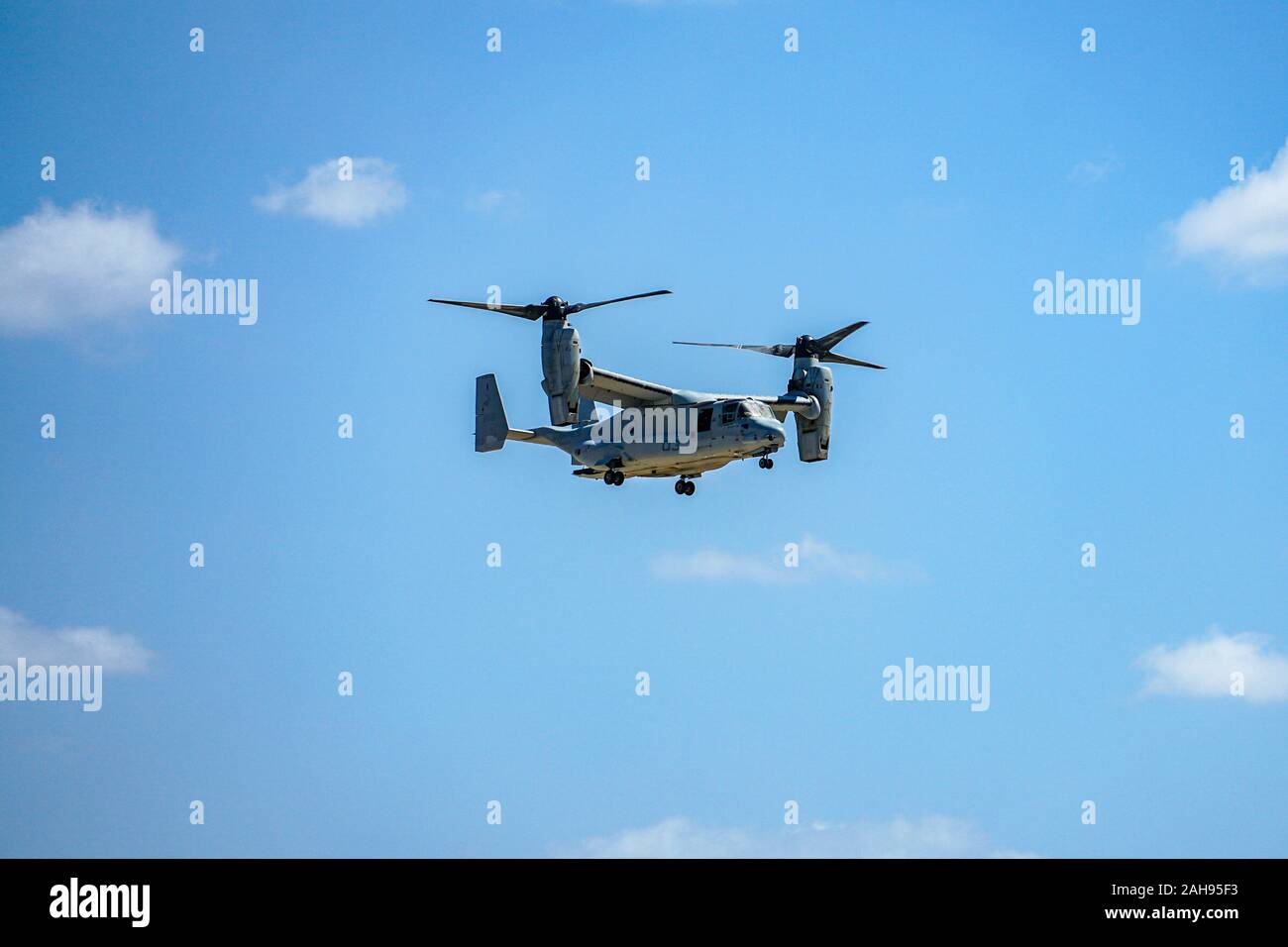 Bell Boeing V-22 Osprey army helicopter hovering on a blue sky ...