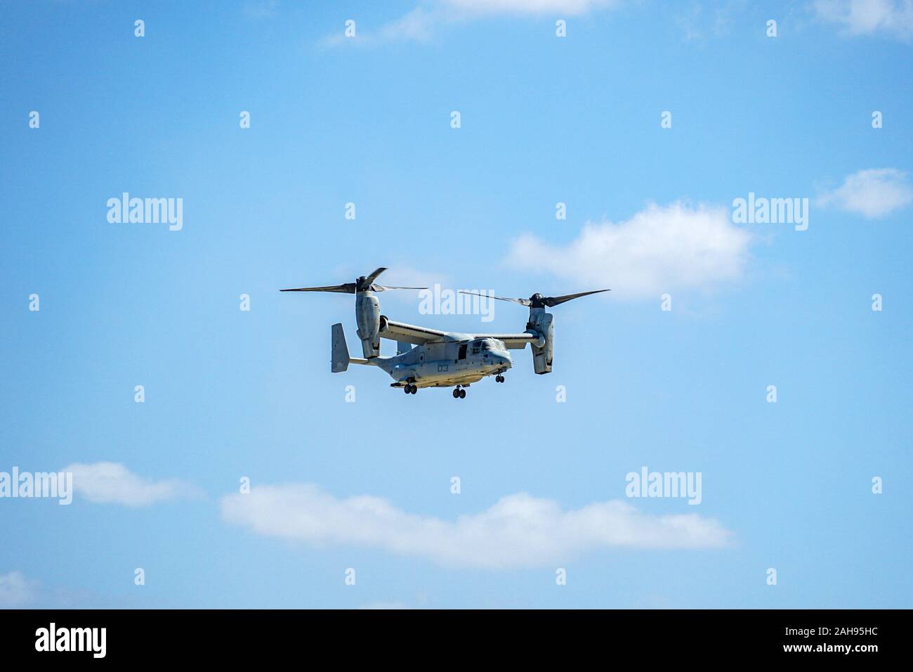 Bell Boeing V-22 Osprey army helicopter hovering on a blue sky ...