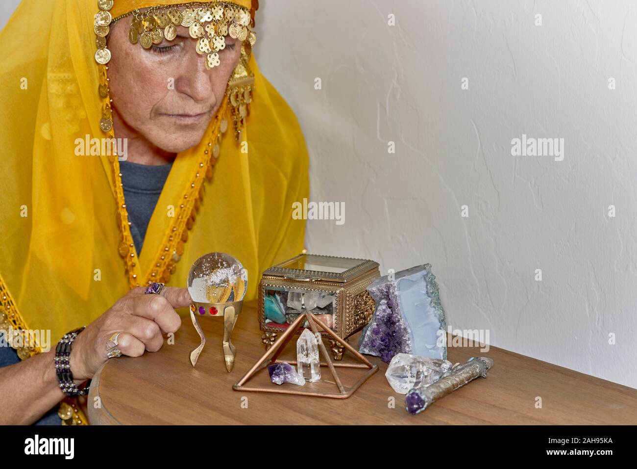 Psychic Reader pointing into a crystal ball with other crystals on the ...