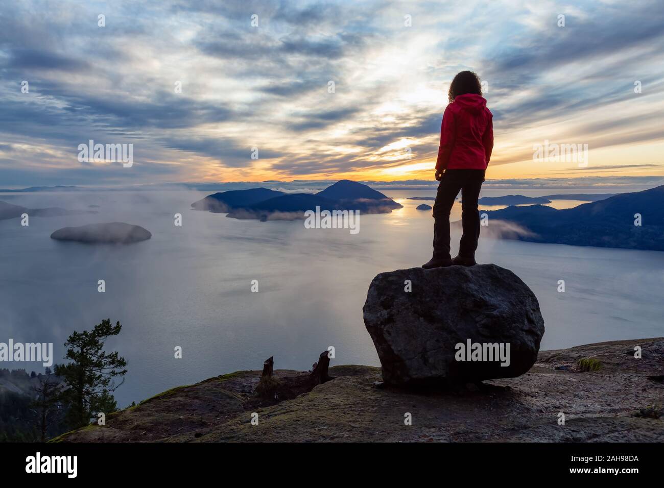 Adventurous Girl on top of a Mountain during Sunset Stock Photo - Alamy