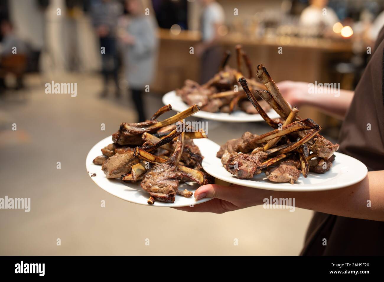 fresh cooked lamb chops on plate being served by waiter Stock Photo - Alamy