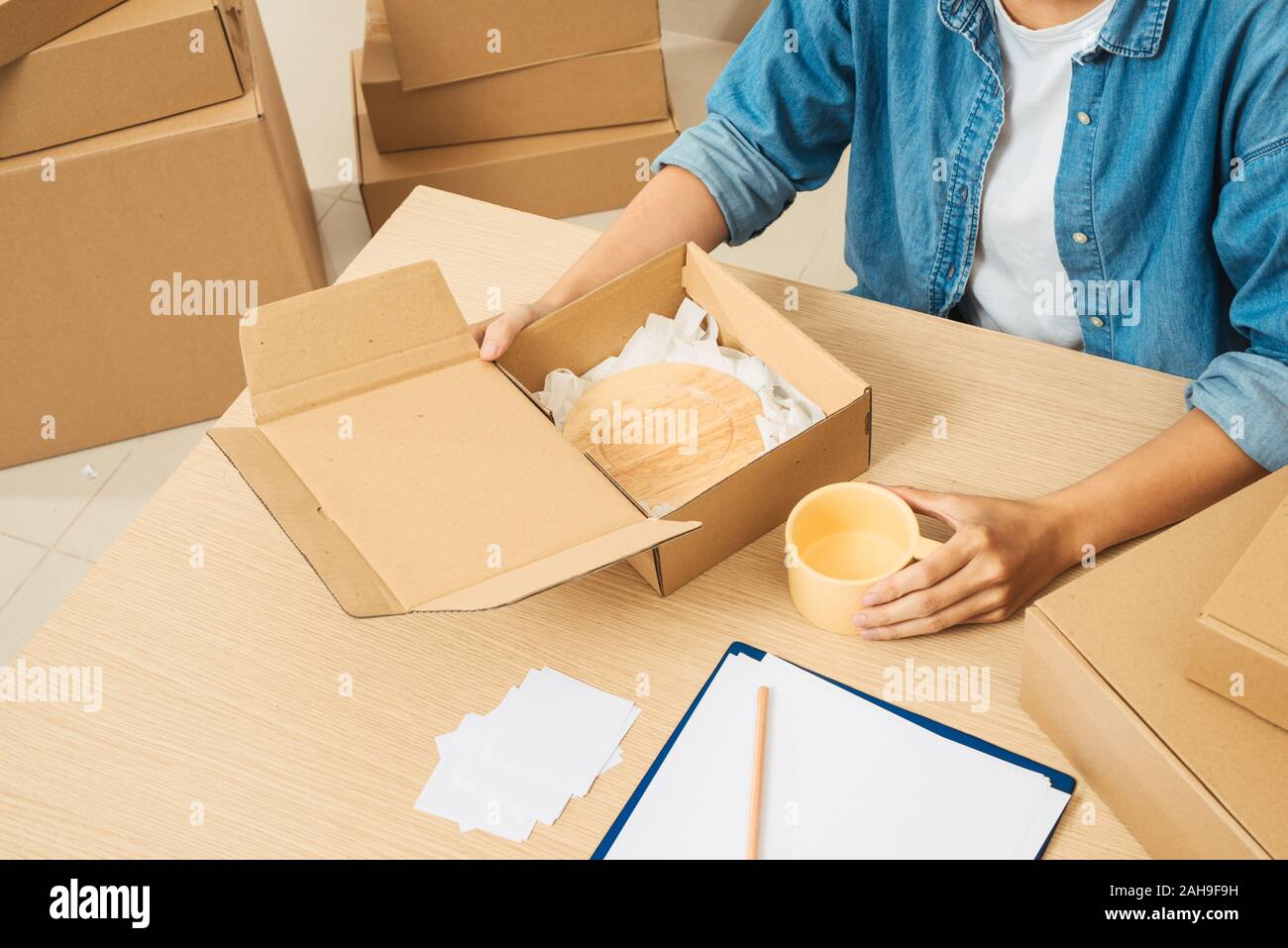 Woman packing cardboard boxes , picking and putting products Stock ...
