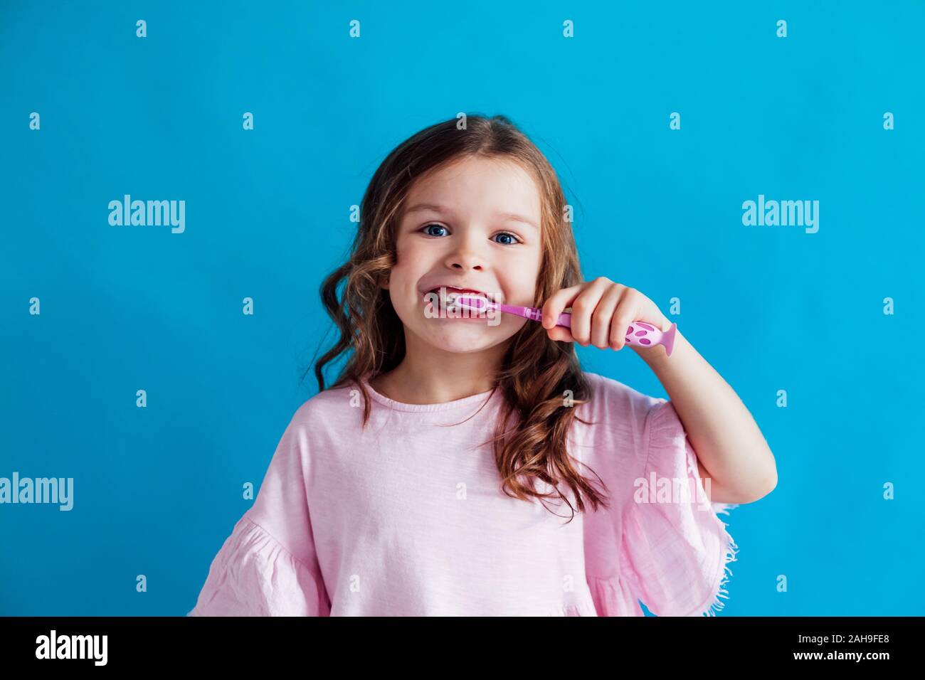 little girl brushing his teeth with a toothbrush dent Stock Photo - Alamy