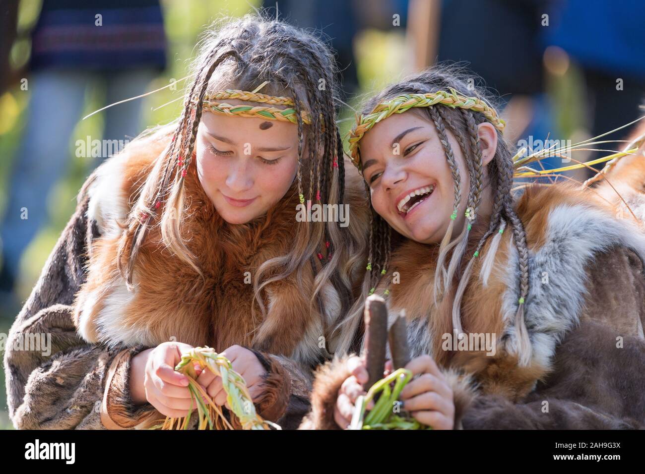 Two smiling girls in traditional clothing aboriginal of Kamchatka ...