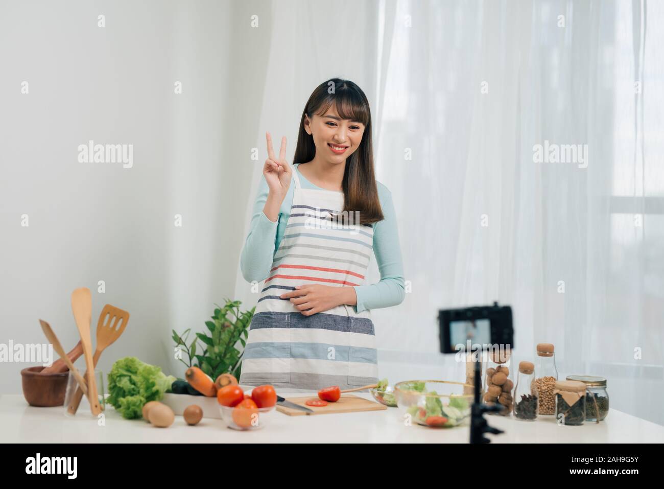Online cooking classes. Food blogging. Woman preparing meal and ...