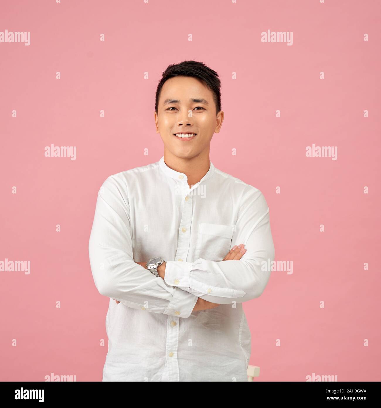 Portrait of confident Asian man standing with his arms folded and ...