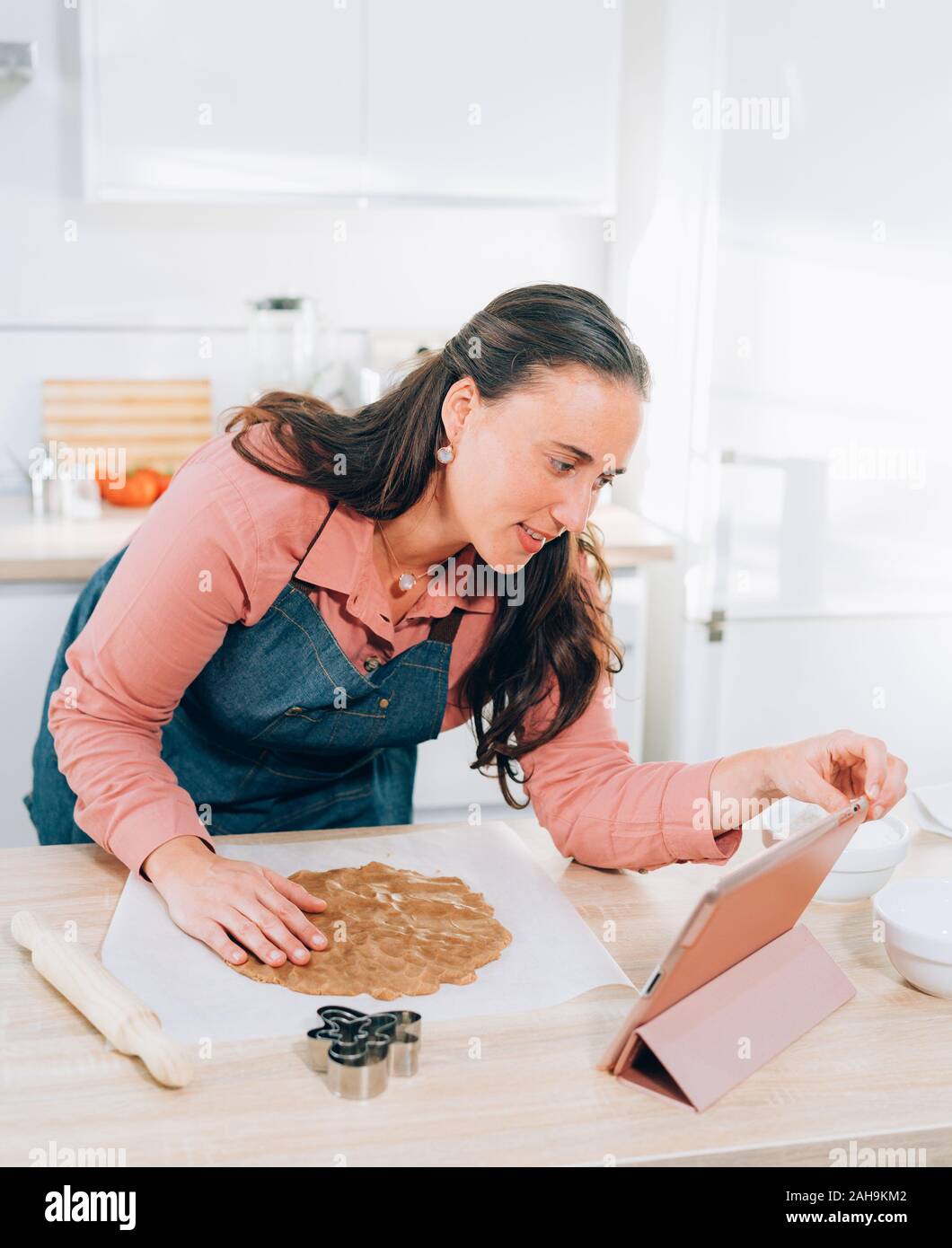 Woman making cookies using recipe hi-res stock photography and images ...