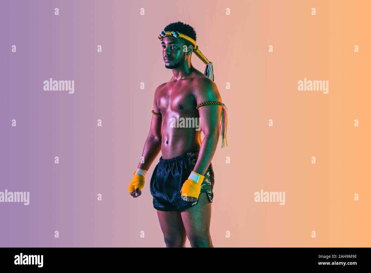 Muay thai. Young man exercising thai boxing on gradient background in ...