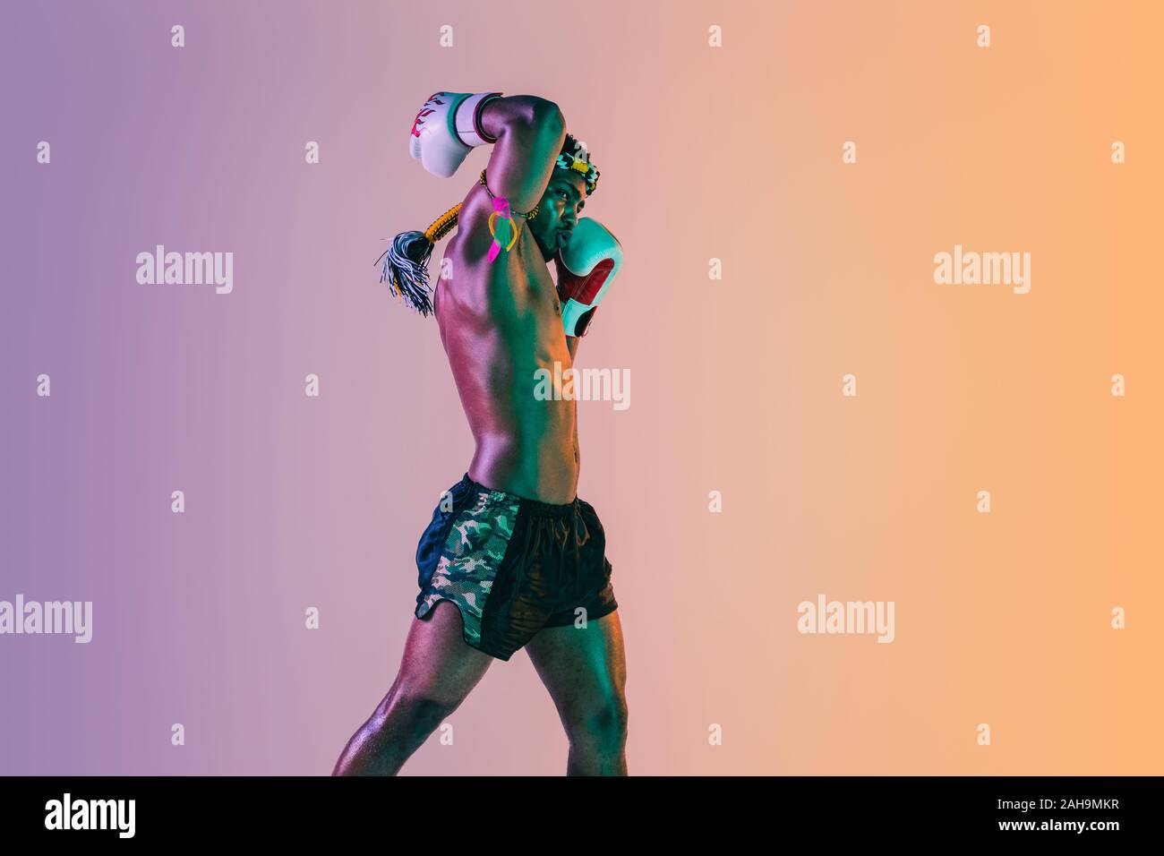 Muay thai. Young man exercising thai boxing on gradient background in ...