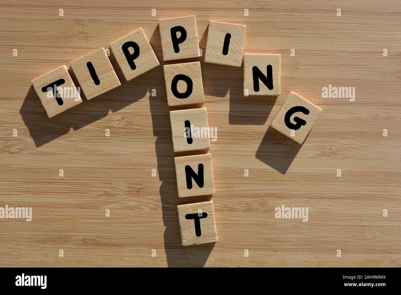 Tipping Point in wooden alphabet letters on a bamboo wood background ...