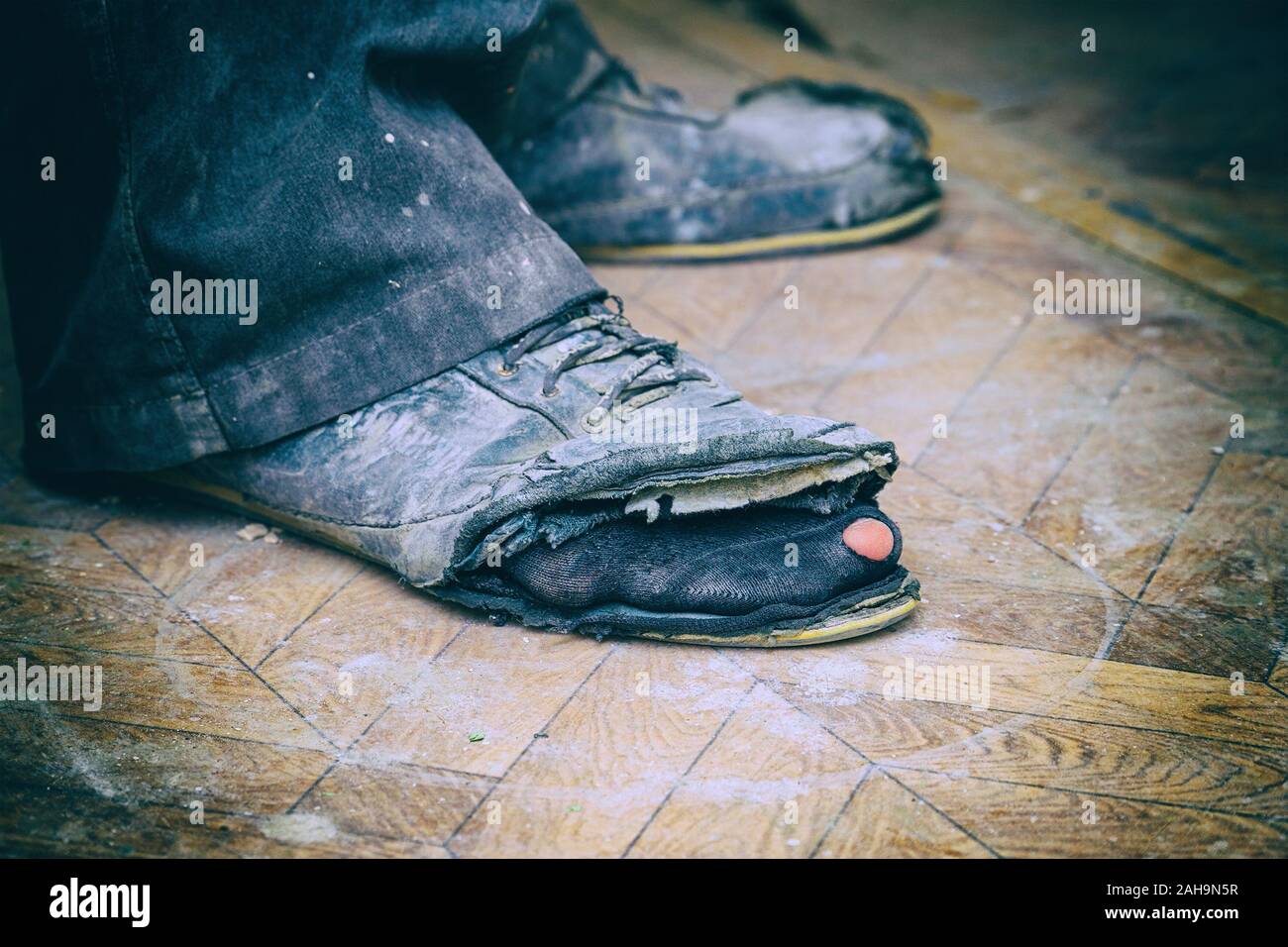 Old torn boots on the man's feet. Boots with holes. Selective focus ...