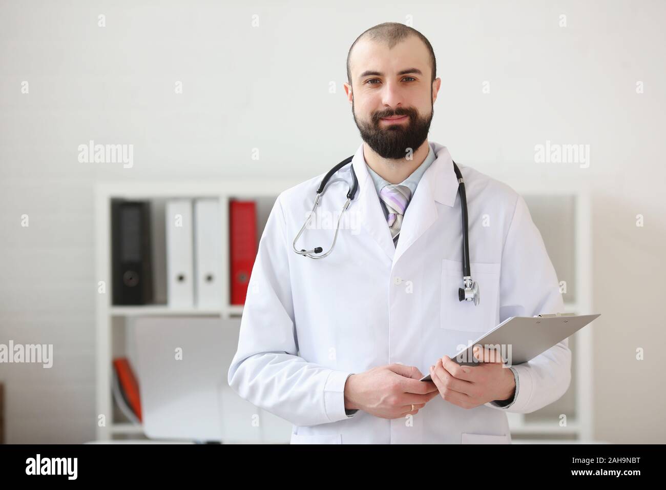 Smiling doctor holding notes hi-res stock photography and images - Alamy