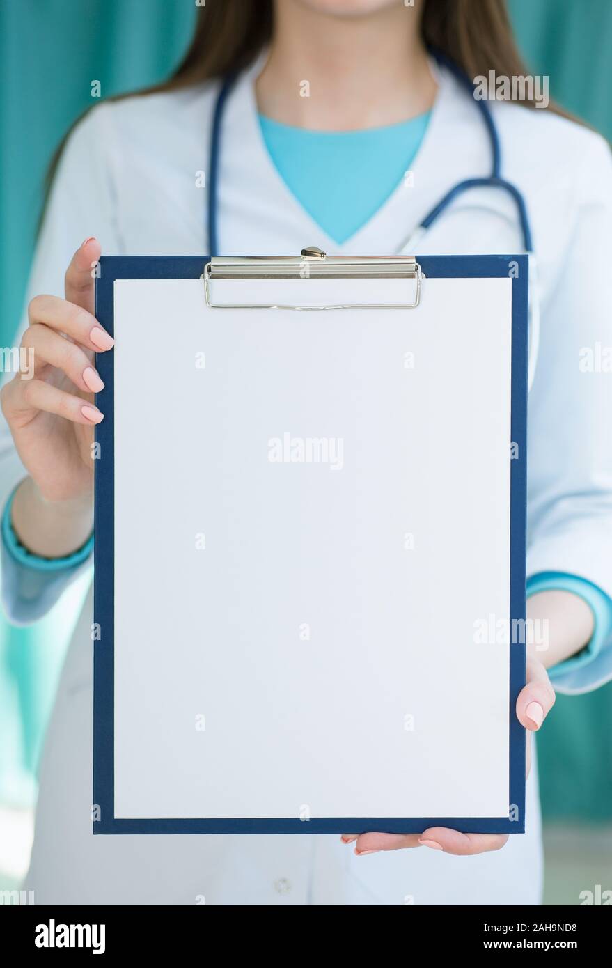 Medical doctor holding folder for notes in hands Stock Photo - Alamy