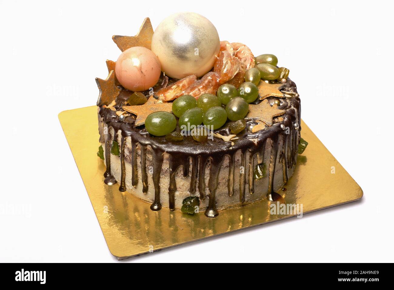 A beautiful cake decorated with grapes chocolate, with decor elements ...