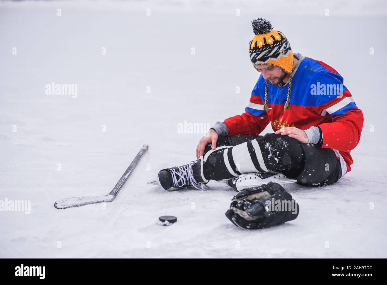 tired player sitting on the ice one Stock Photo - Alamy