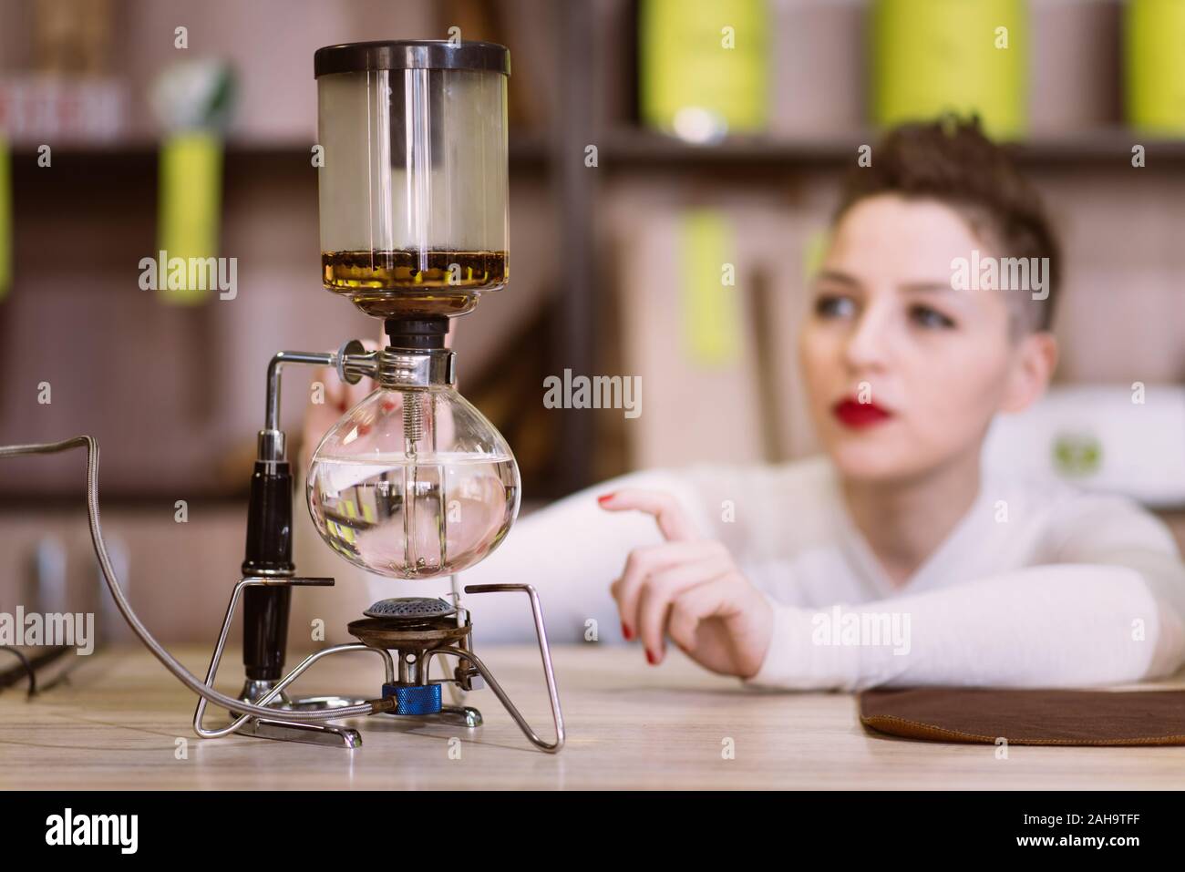 A girl is making tea in a siphon Stock Photo - Alamy
